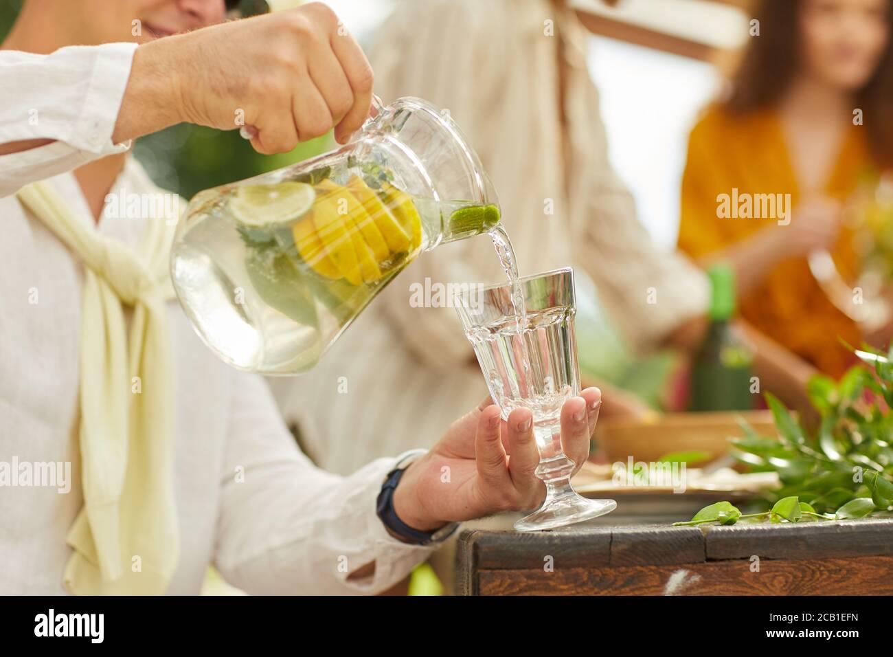 Close up of unrecognizable man pouring lemonade into glass cup while ...