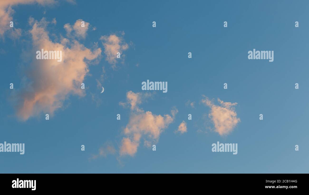 Blue sky with pink clouds at sunset and the month Stock Photo - Alamy