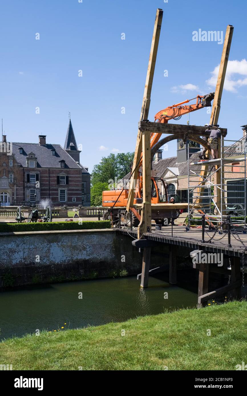 Construction workers with mobile crane and grab repair the wooden ...