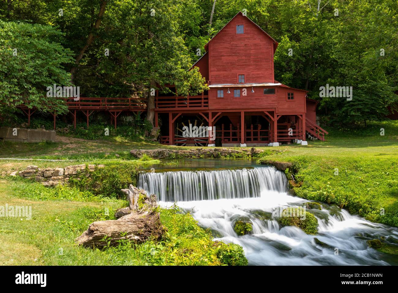 An old red grist mill with a small waterfall Stock Photo - Alamy