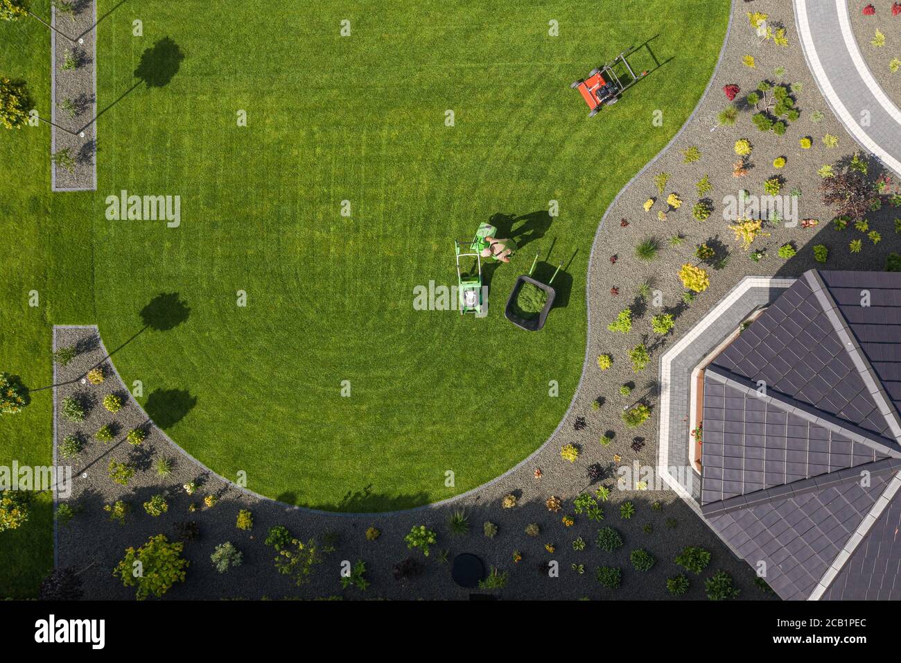 Aerial View Of Male Gardener Cutting Grass With Lawn Mower On Vast ...
