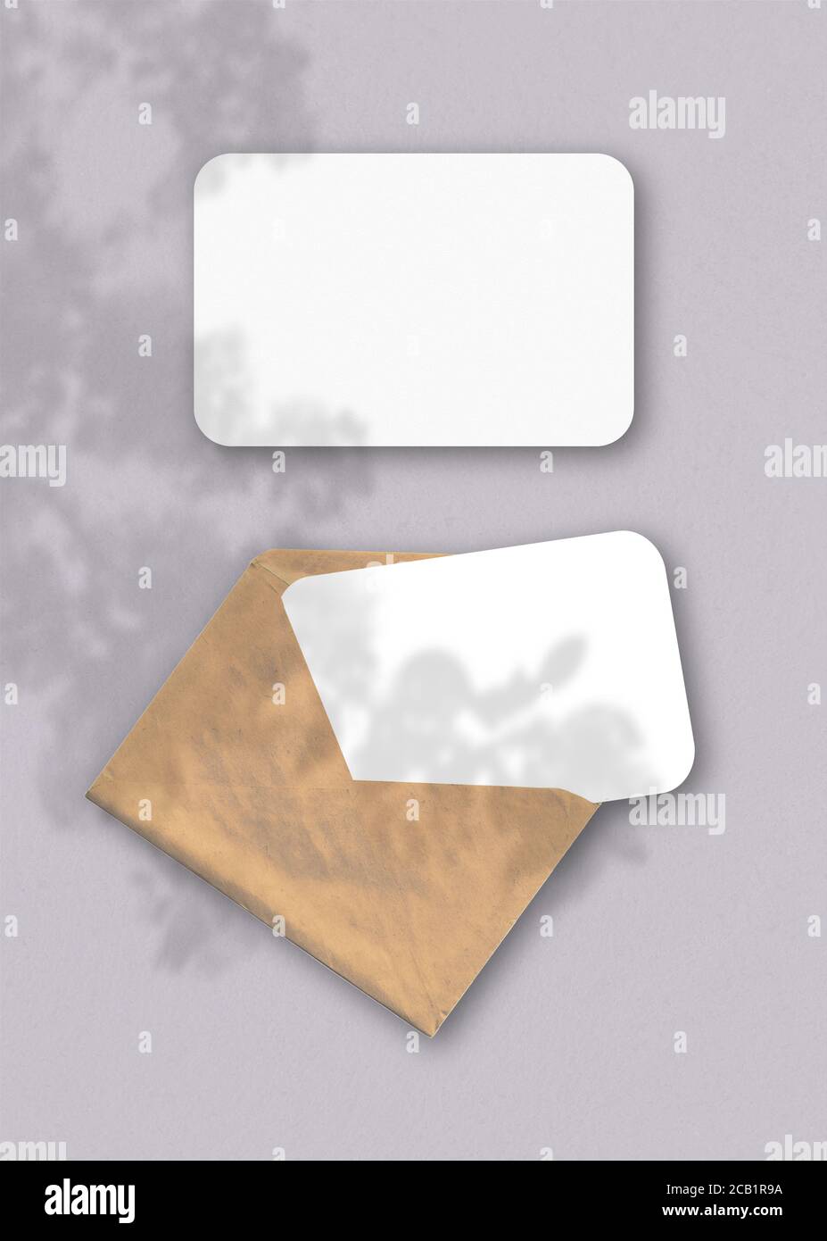 An envelope with two sheets of textured white paper on the grey ...