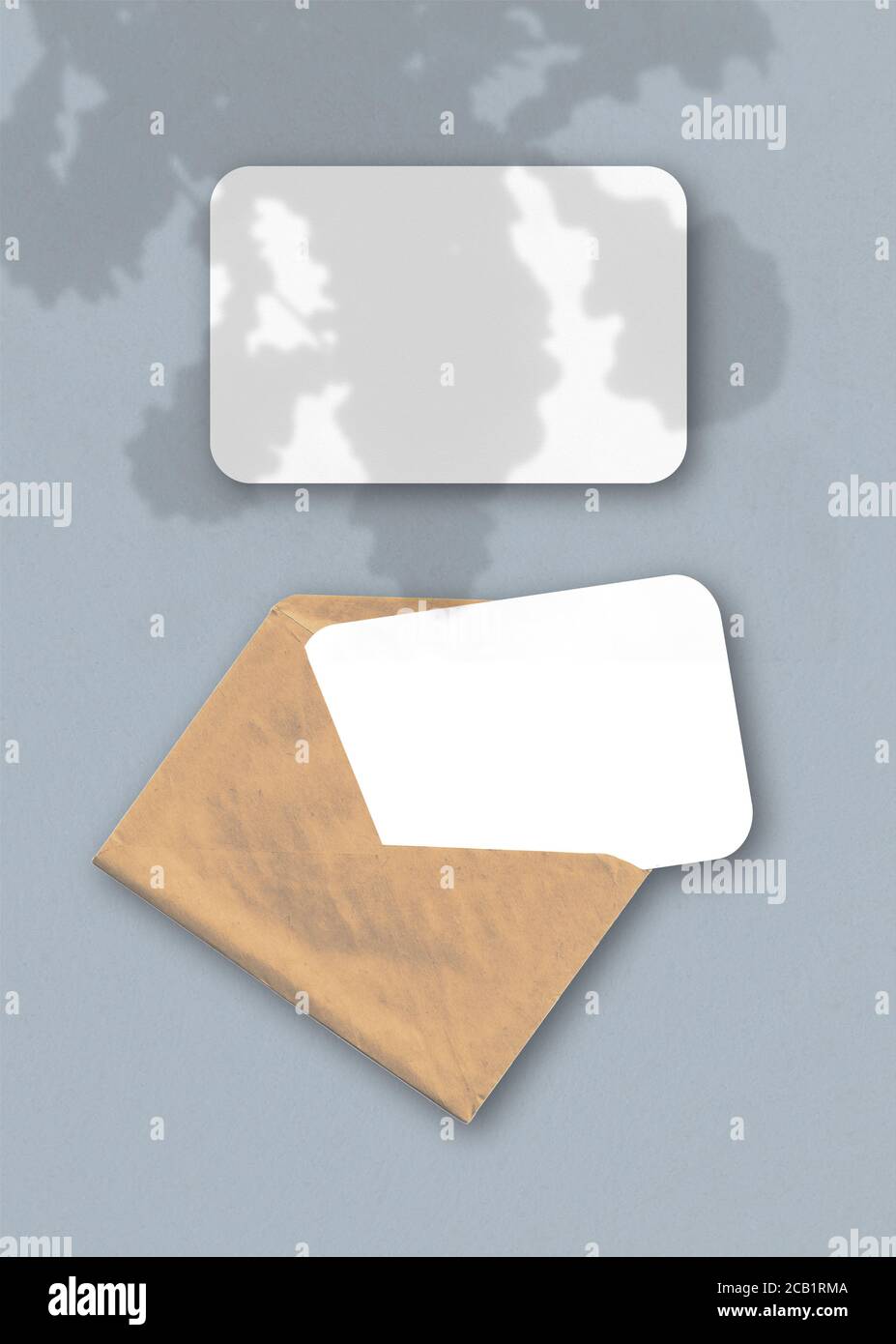 An envelope with two sheets of textured white paper on the grey ...