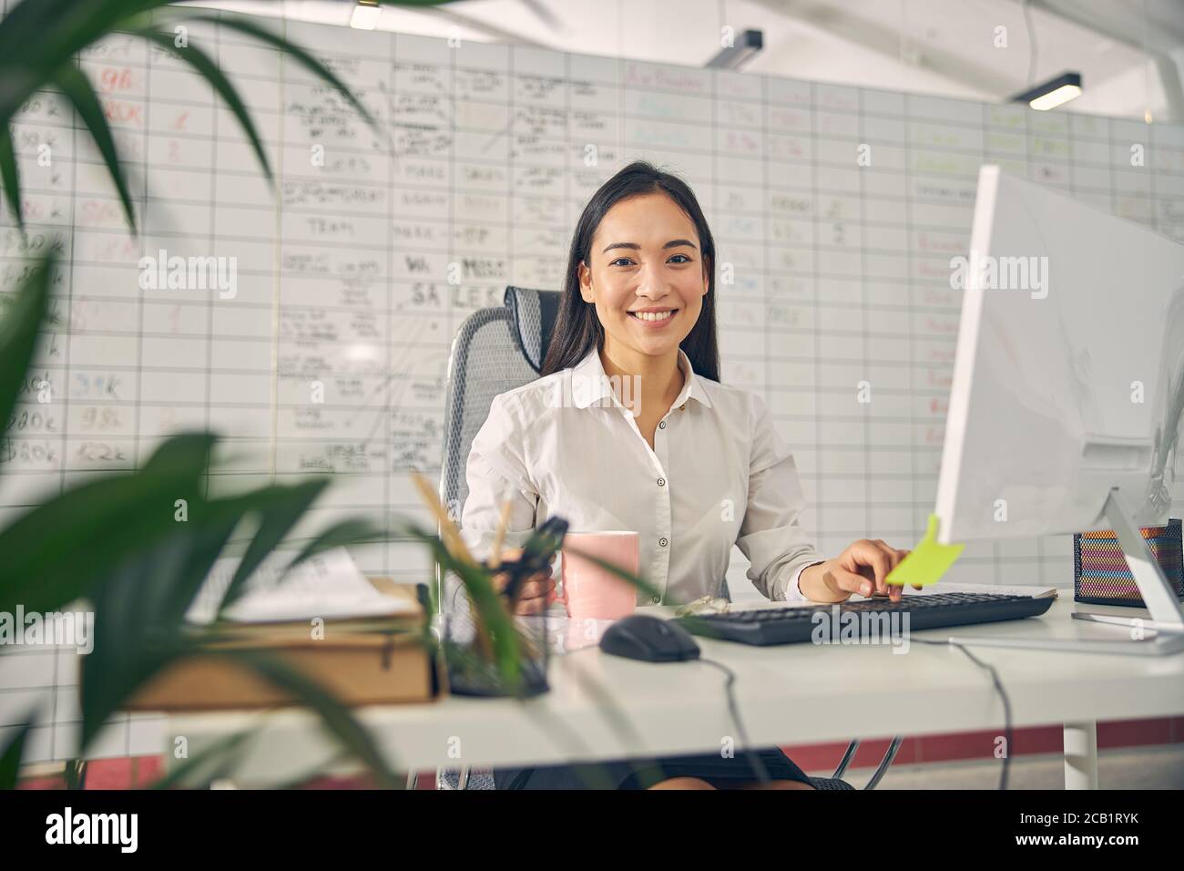 Positive delighted young woman being at work Stock Photo - Alamy