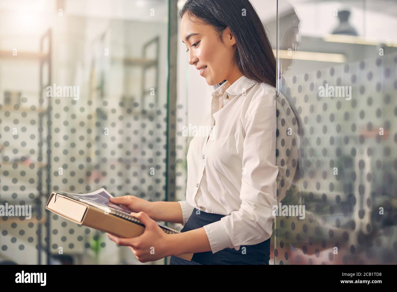 Positive delighted young woman looking at her notes Stock Photo - Alamy