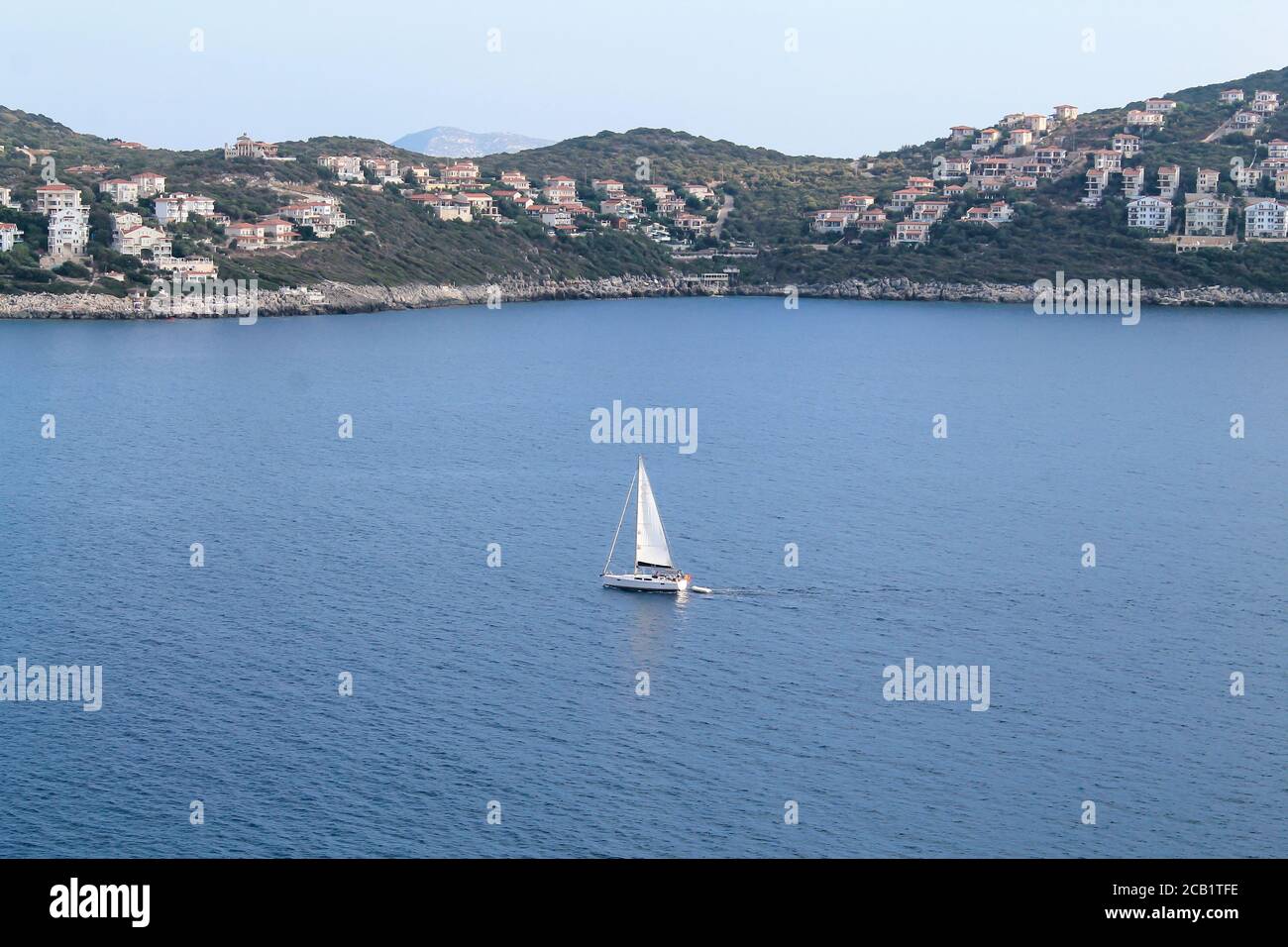 Sailboat approaching the shore. Sailboat alone in the middle of the sea ...
