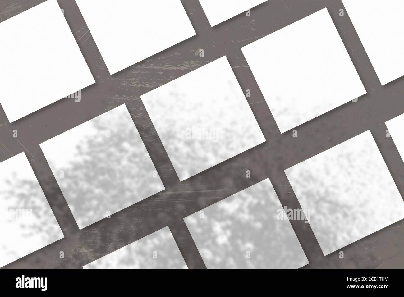 Several square sheets of white textured paper against a grey wall ...