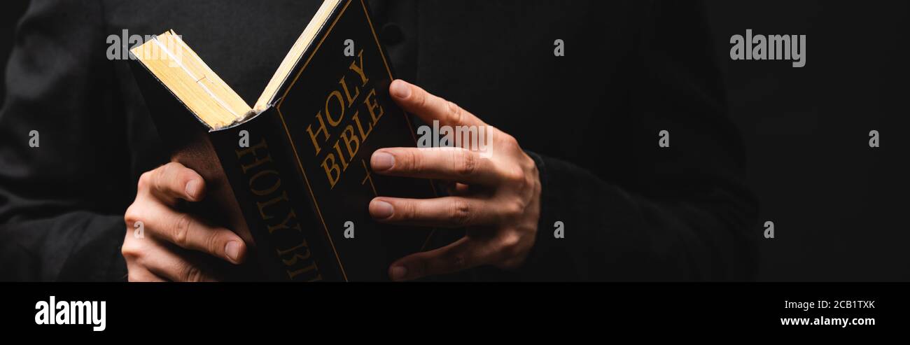 horizontal image of pastor reading holy bible isolated on black Stock ...