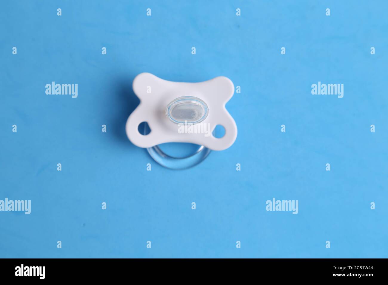 Top view closeup of a pacifier of a baby used to suck upon on a blue ...