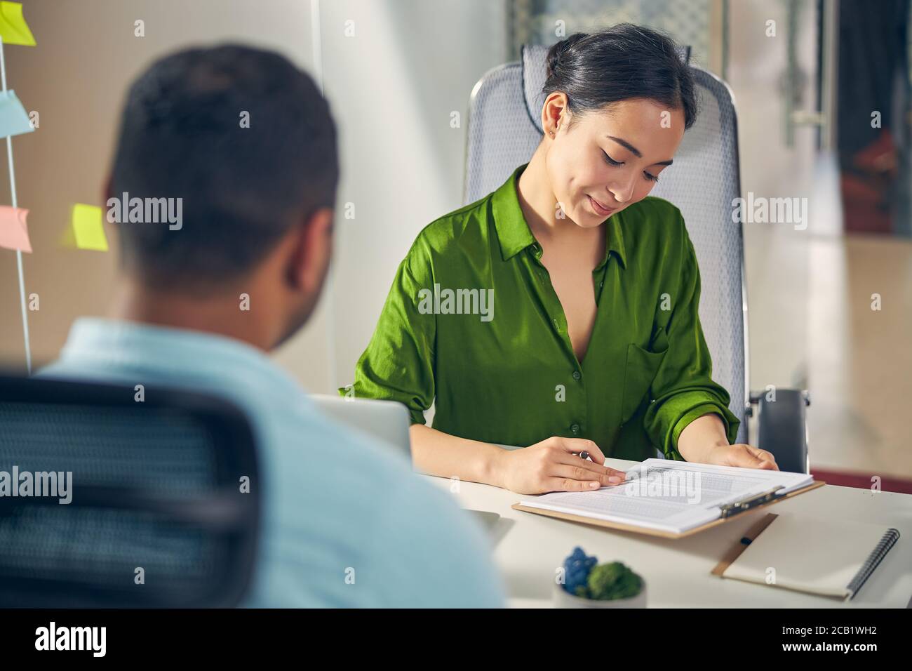 Pleased young woman checking form for the workers Stock Photo - Alamy