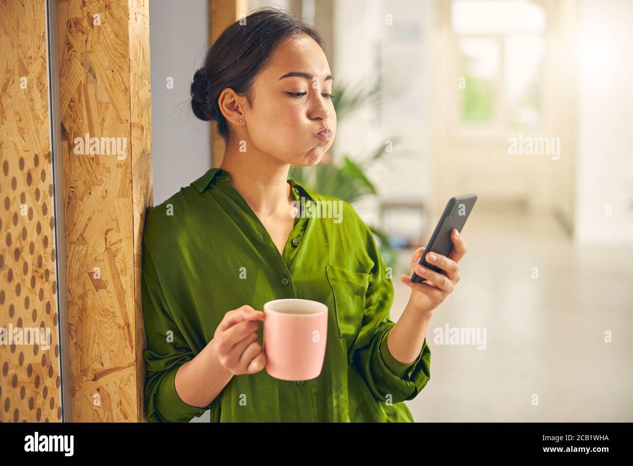 Emotional brunette female staring at her telephone Stock Photo - Alamy