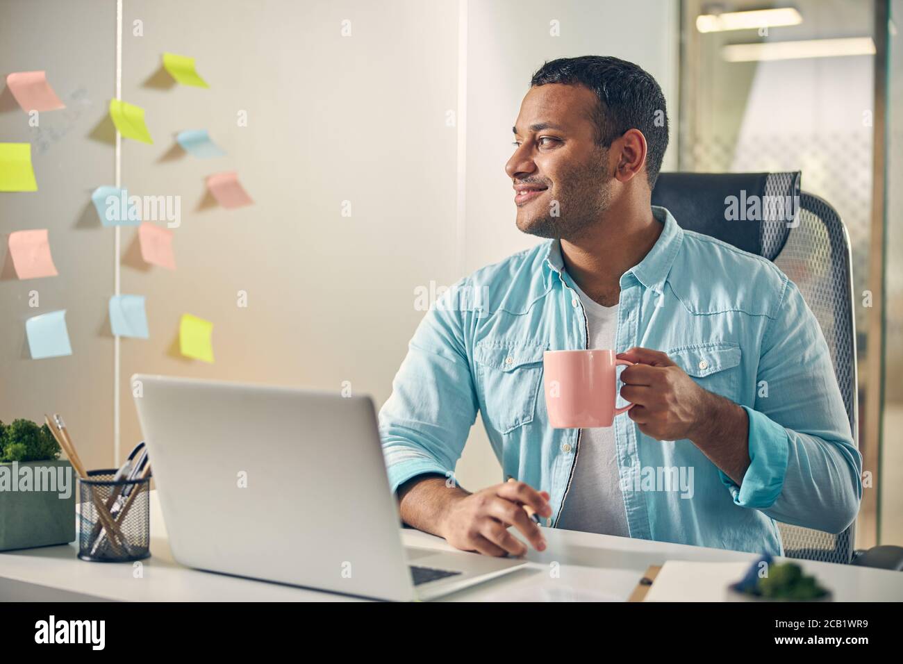 Pleased international male person looking at notes Stock Photo - Alamy