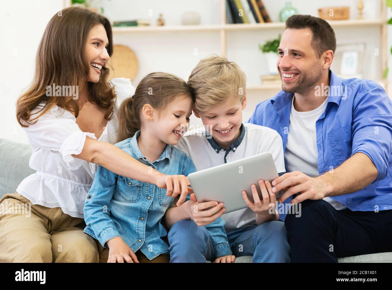Parents And Children Using Tablet Watching Film Together At Home Stock ...