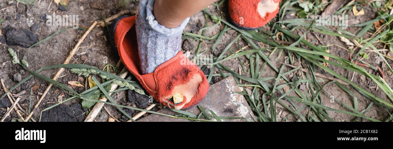 panoramic crop of poor kid standing in ripped shoes Stock Photo - Alamy