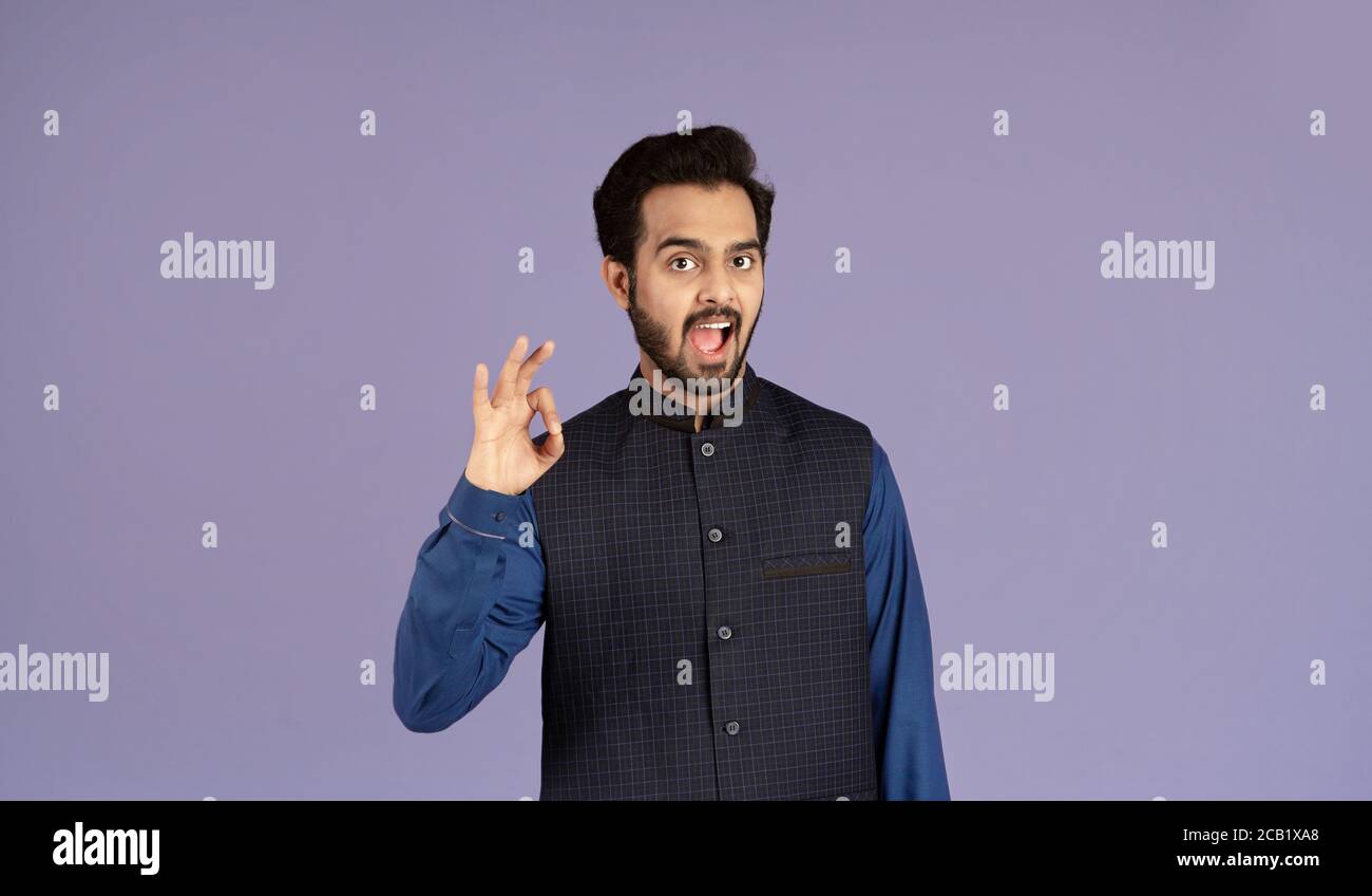 Expressing positivity. Happy Indian guy showing okay gesture over lilac ...