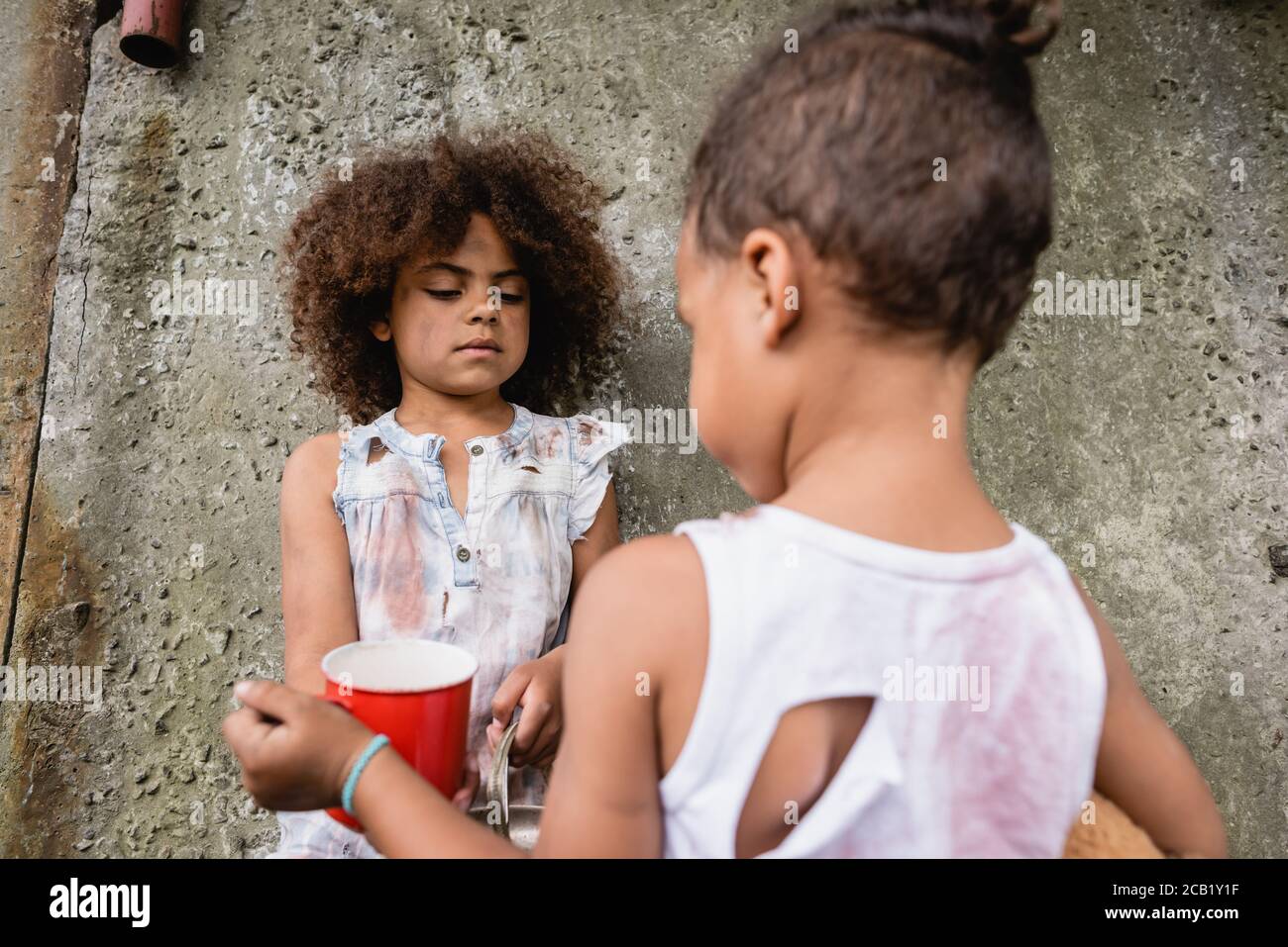 Selective focus of destitute afican american kid holding metal plate ...