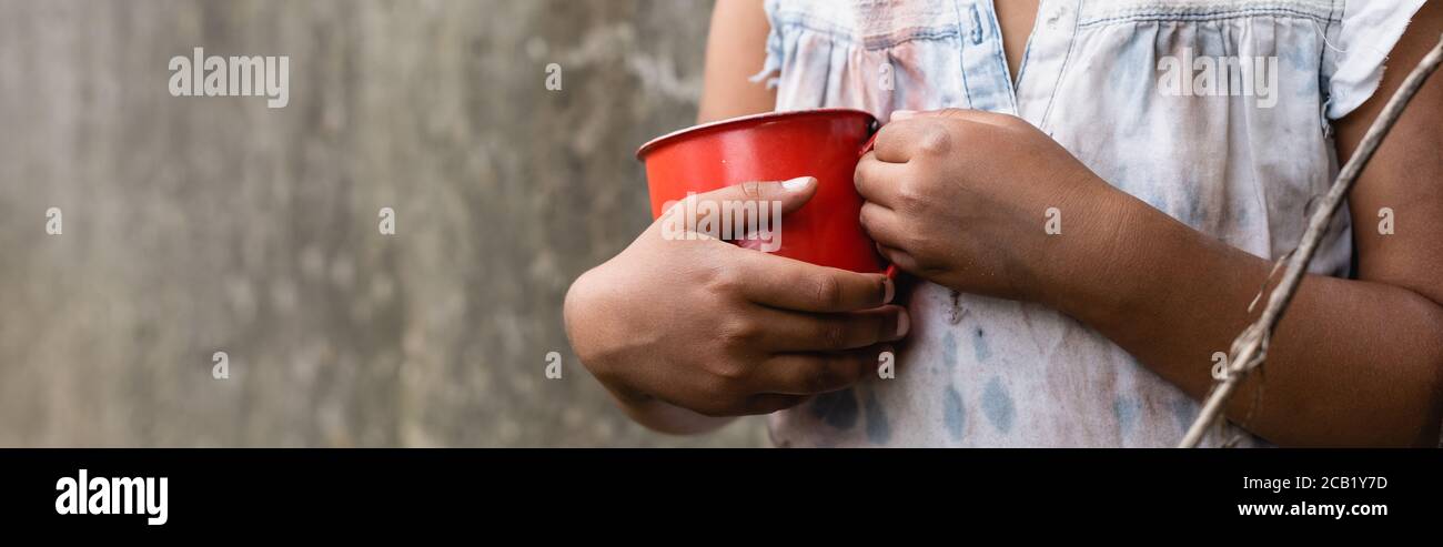 Panoramic crop of poor african american child holding metal cup on ...