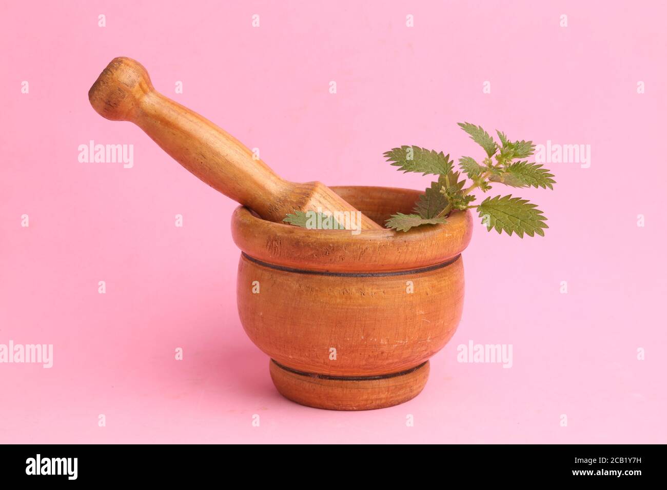 Traditional wooden mortar with mint leaves on the pink background Stock ...