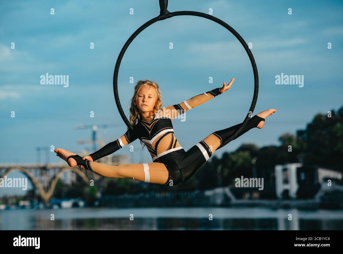 Child girl aerialist performs acrobatic element split in hanging aerial ...