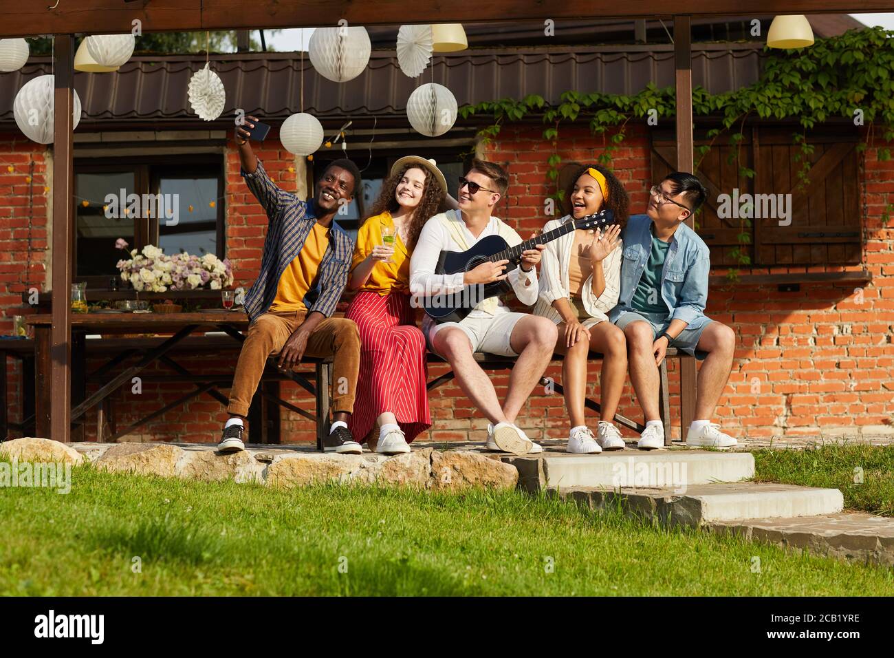 Wide angle portrait of young people enjoying outdoor party in Summer ...