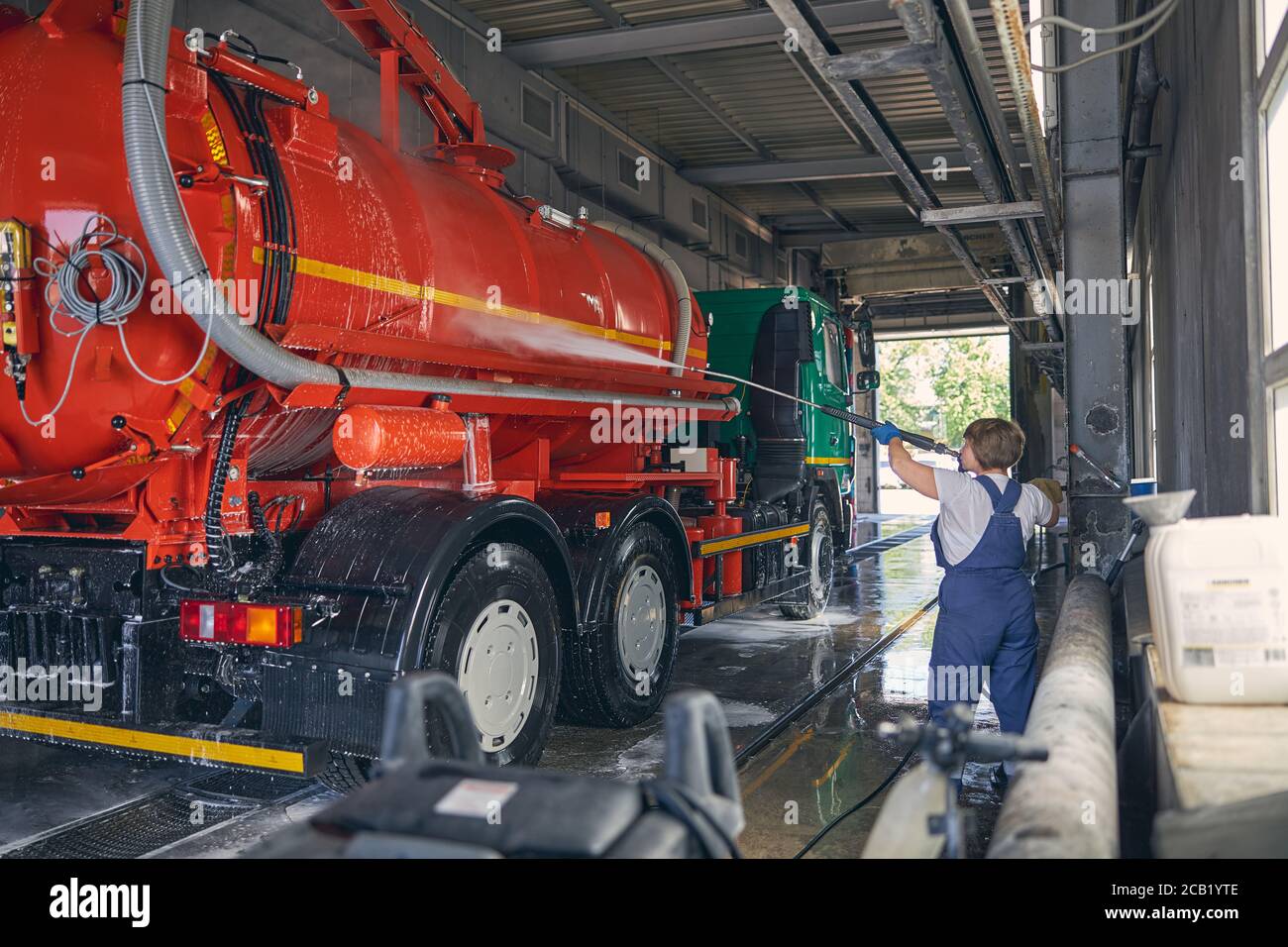 Attentive brunette female person cleaning orange barrel Stock Photo - Alamy
