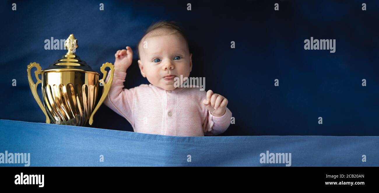 two month old baby with golden cup, victory concept, panoramic mock-up ...