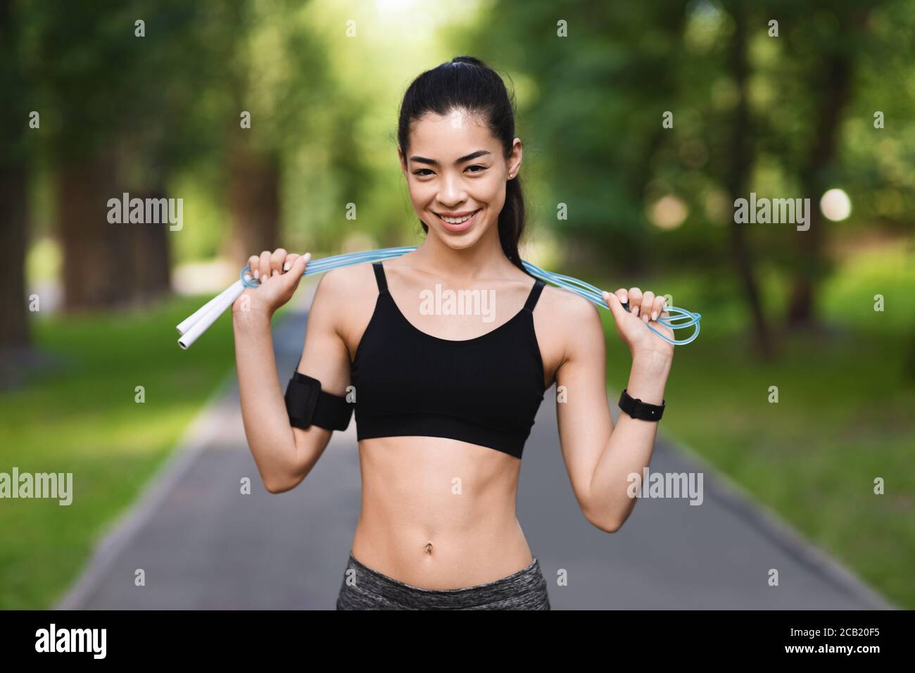 Cardio Training Outdoors. Positive Asian Girl Holding Skipping Rope ...
