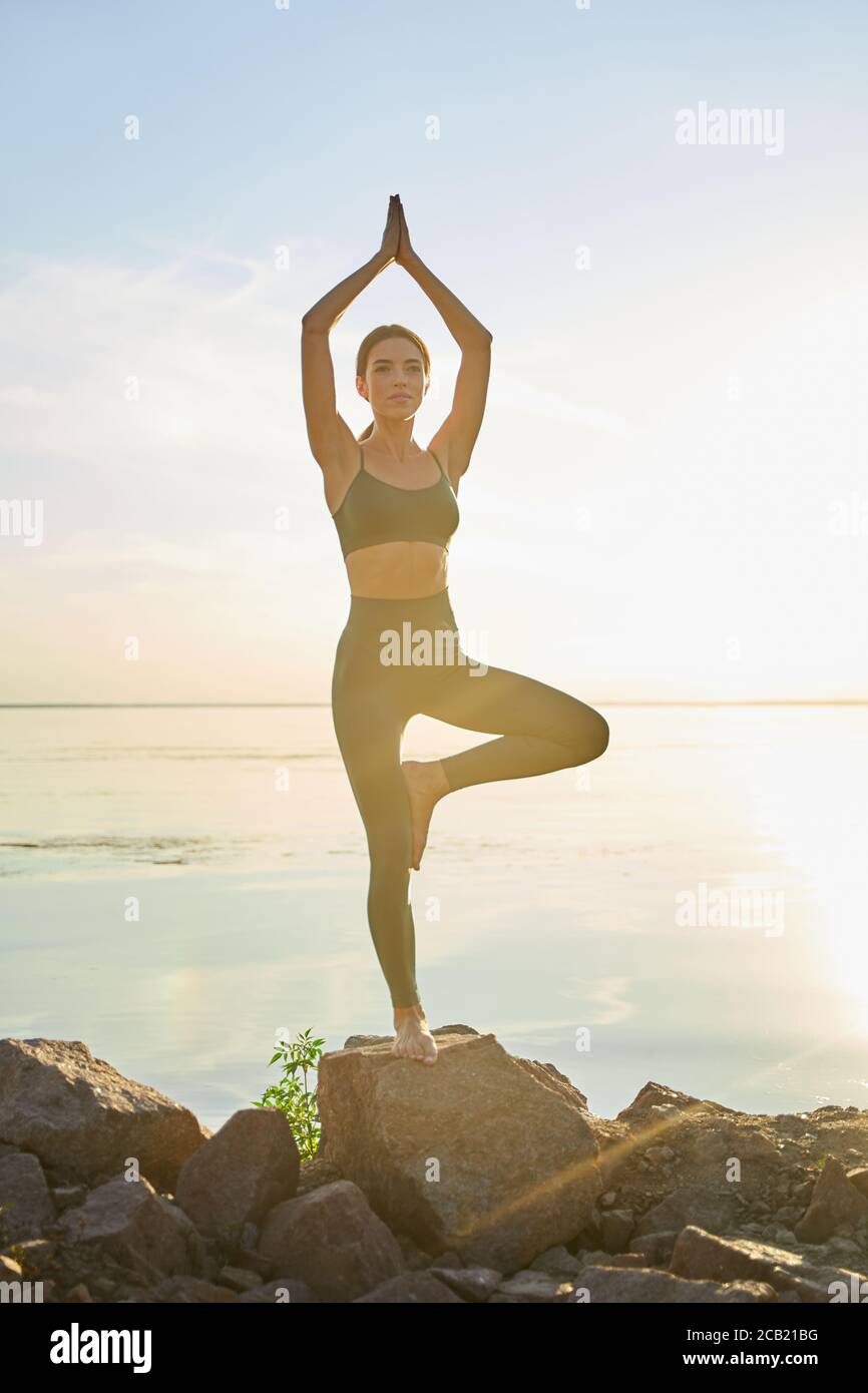Sporty pretty woman doing tree pose or Vrksasana on the beach Stock ...
