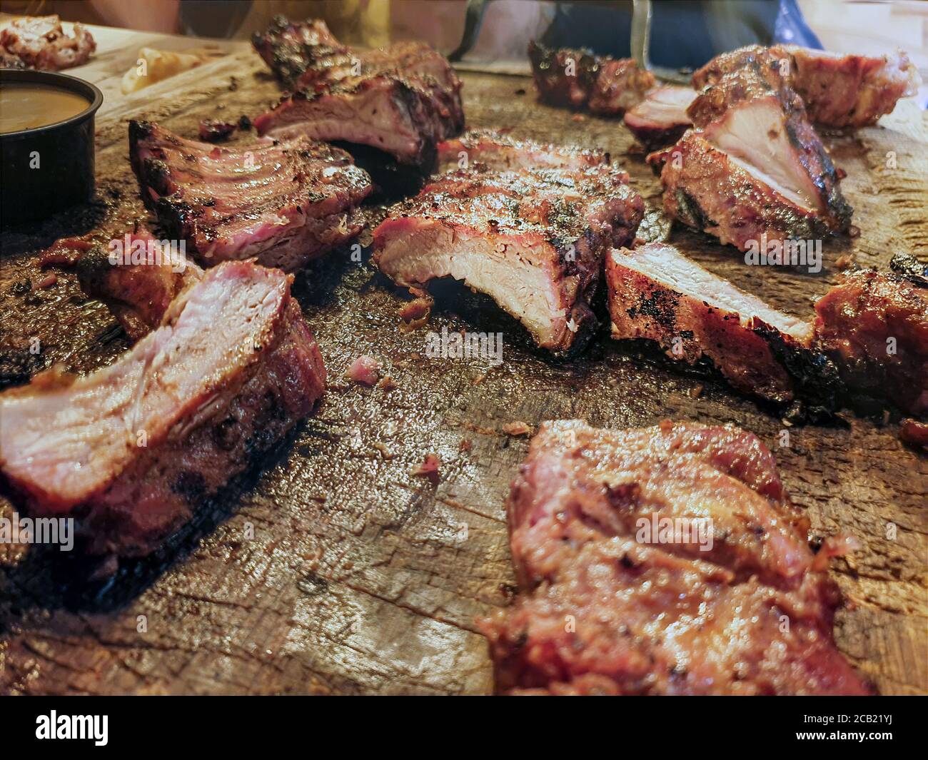Pork ribs on a cutting wooden board. Close up of ready to eat chopped ...