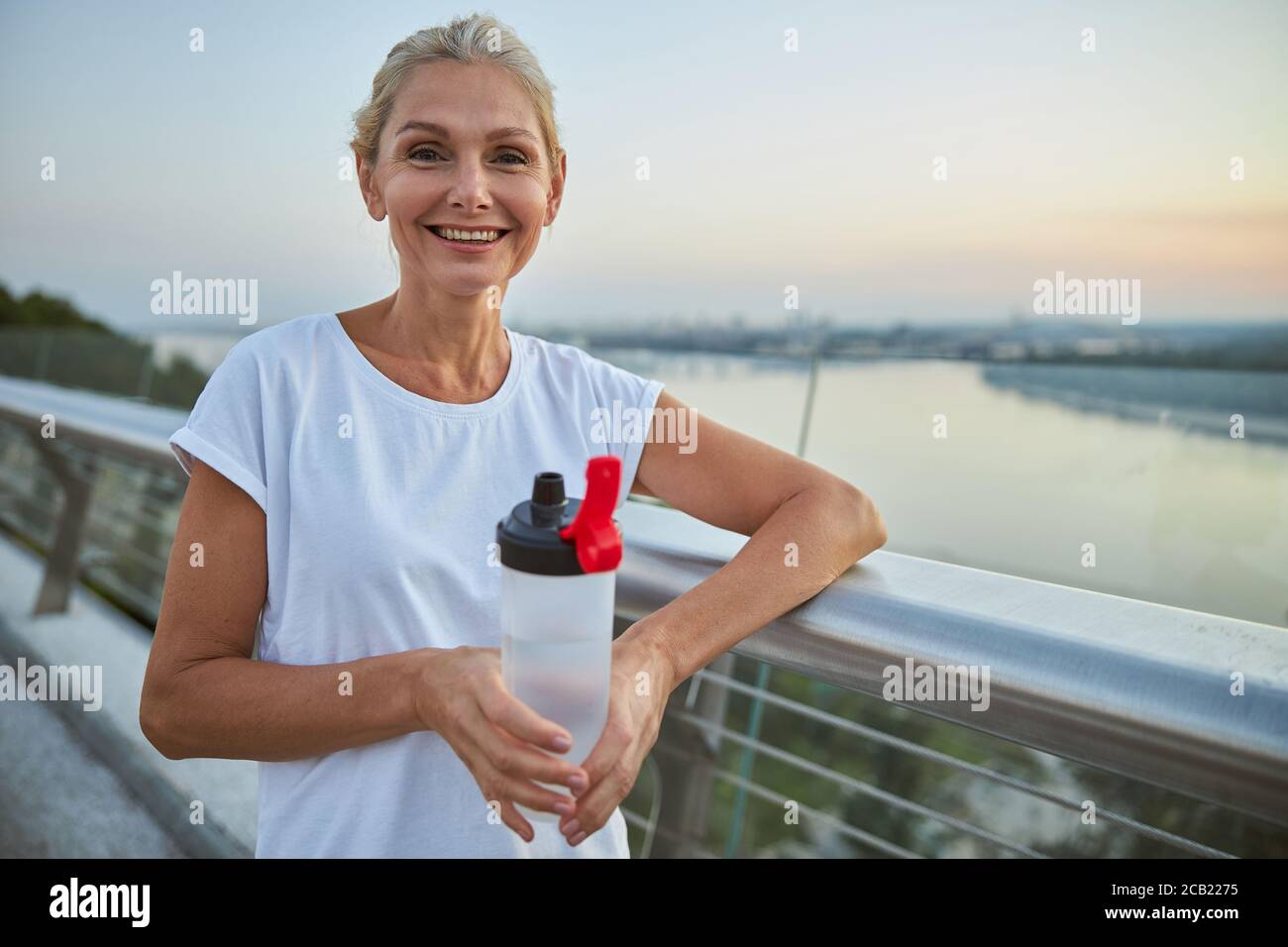 Attractive merry lady standing on a pedestrian bridge Stock Photo - Alamy