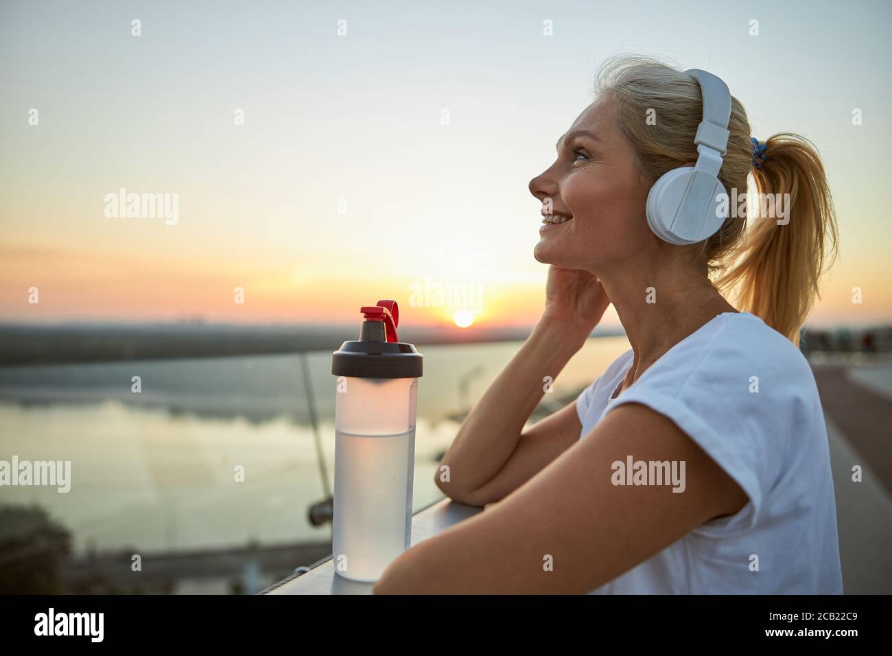 Joyous lady with a ponytail listening to music Stock Photo - Alamy