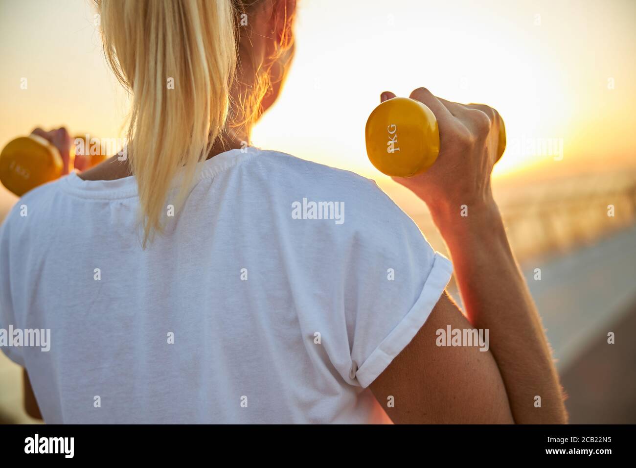 Strong female athlete working out with weights Stock Photo - Alamy