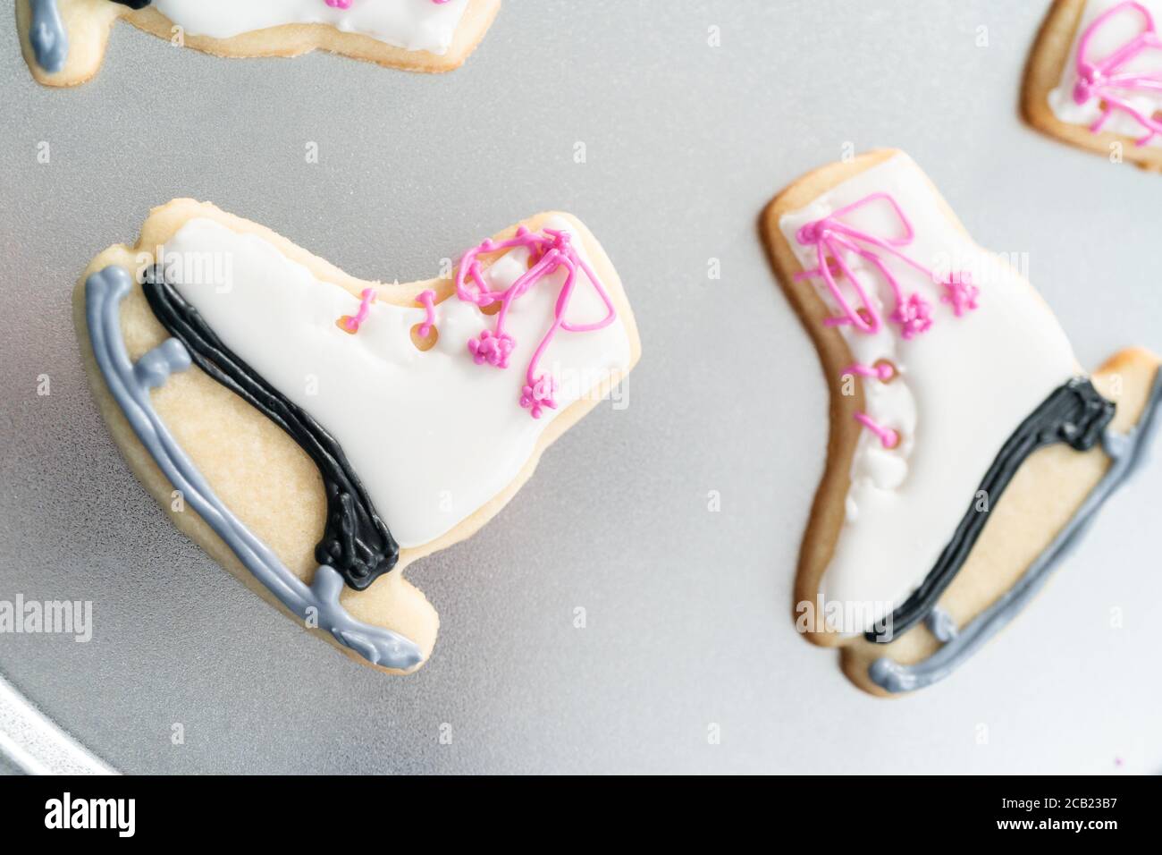 Decorating sugar cookies shaped as figure skates with royal icing Stock ...