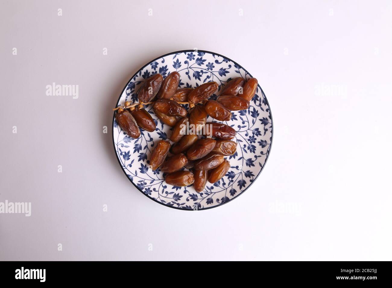 Top view of a plate filled with dates on a white background Stock Photo ...
