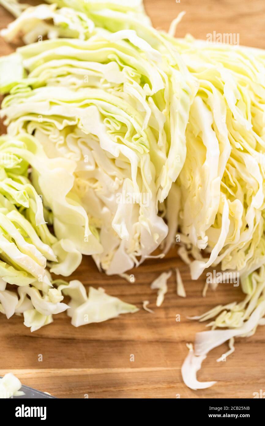 Shredding green cabbage on a wood cutting board Stock Photo - Alamy