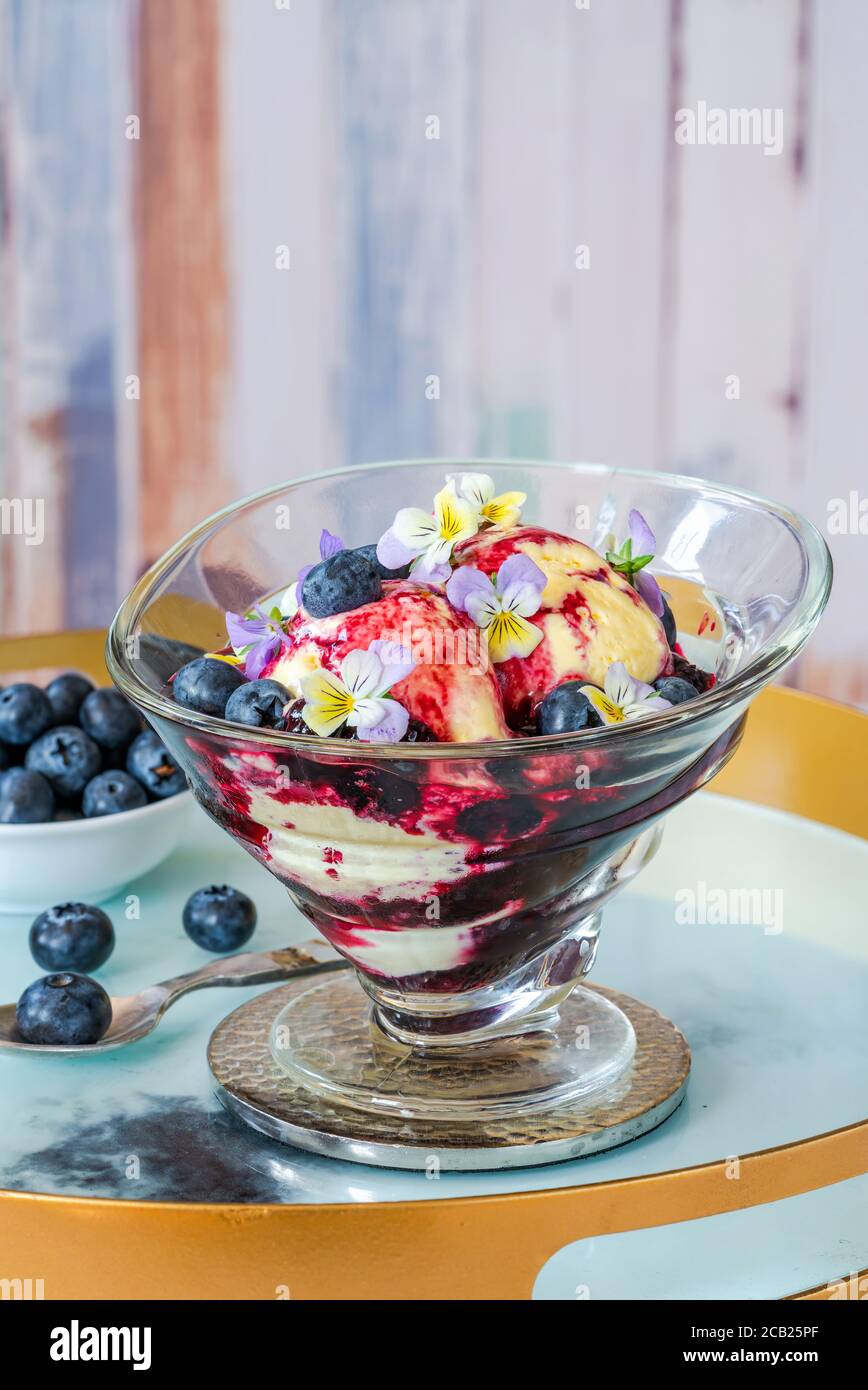 Ice cream dessert with blueberry and cardamom compote garnished with ...