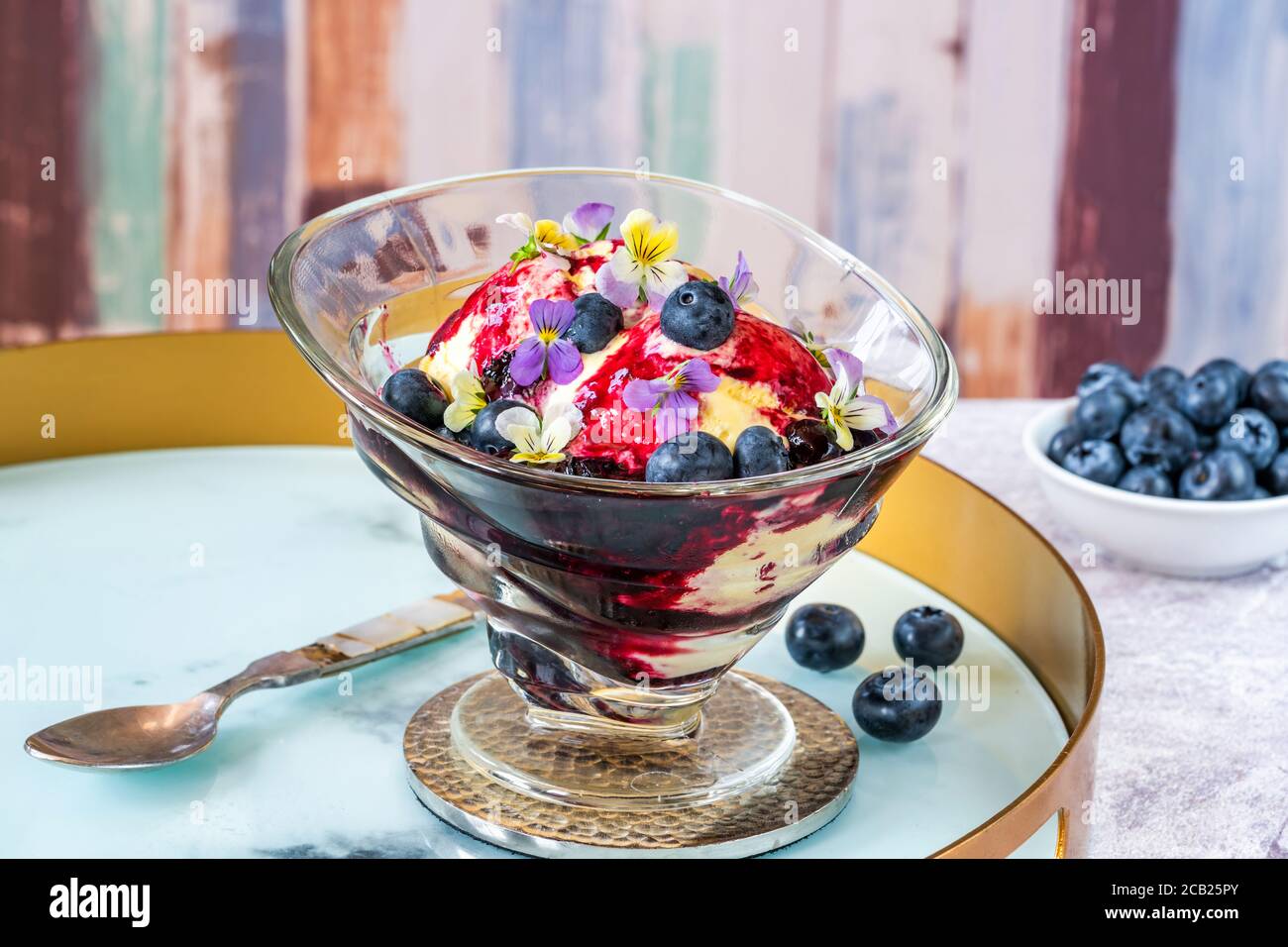 Ice cream dessert with blueberry and cardamom compote garnished with ...