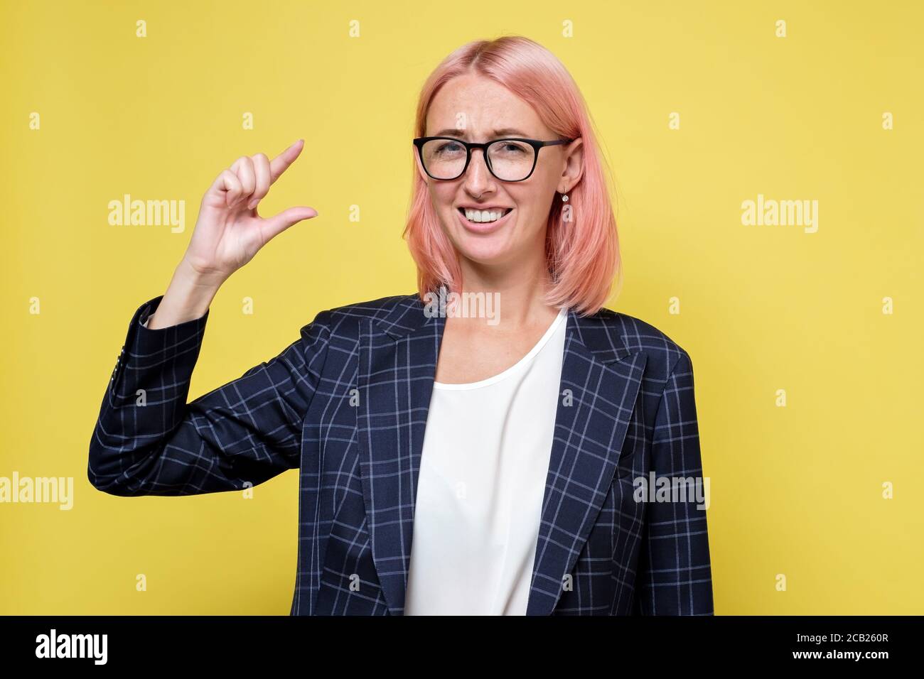 Caucasian young woman showing something small in size with hands Stock ...
