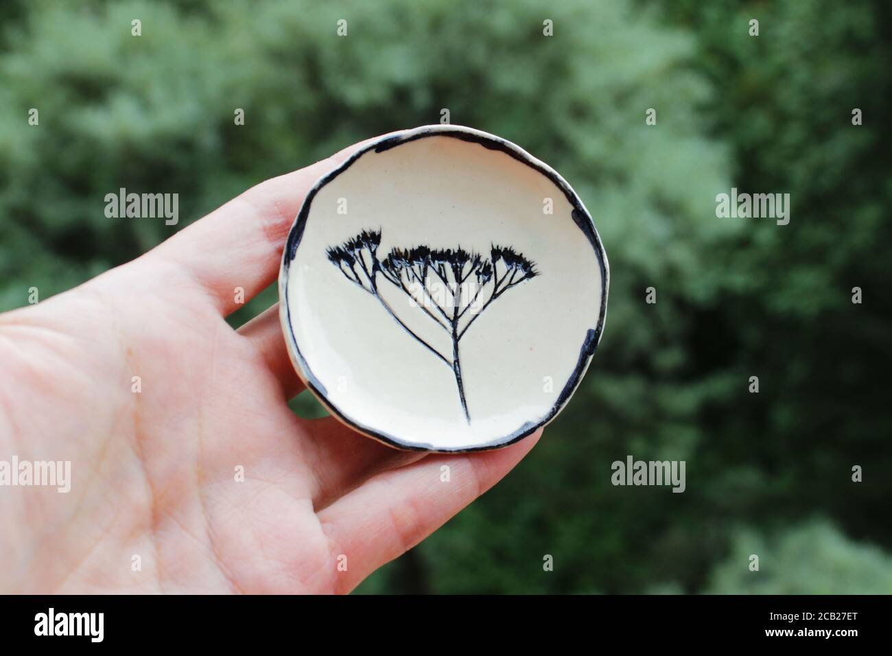 small ceramic plate with a plant print. made from a layer of clay ...