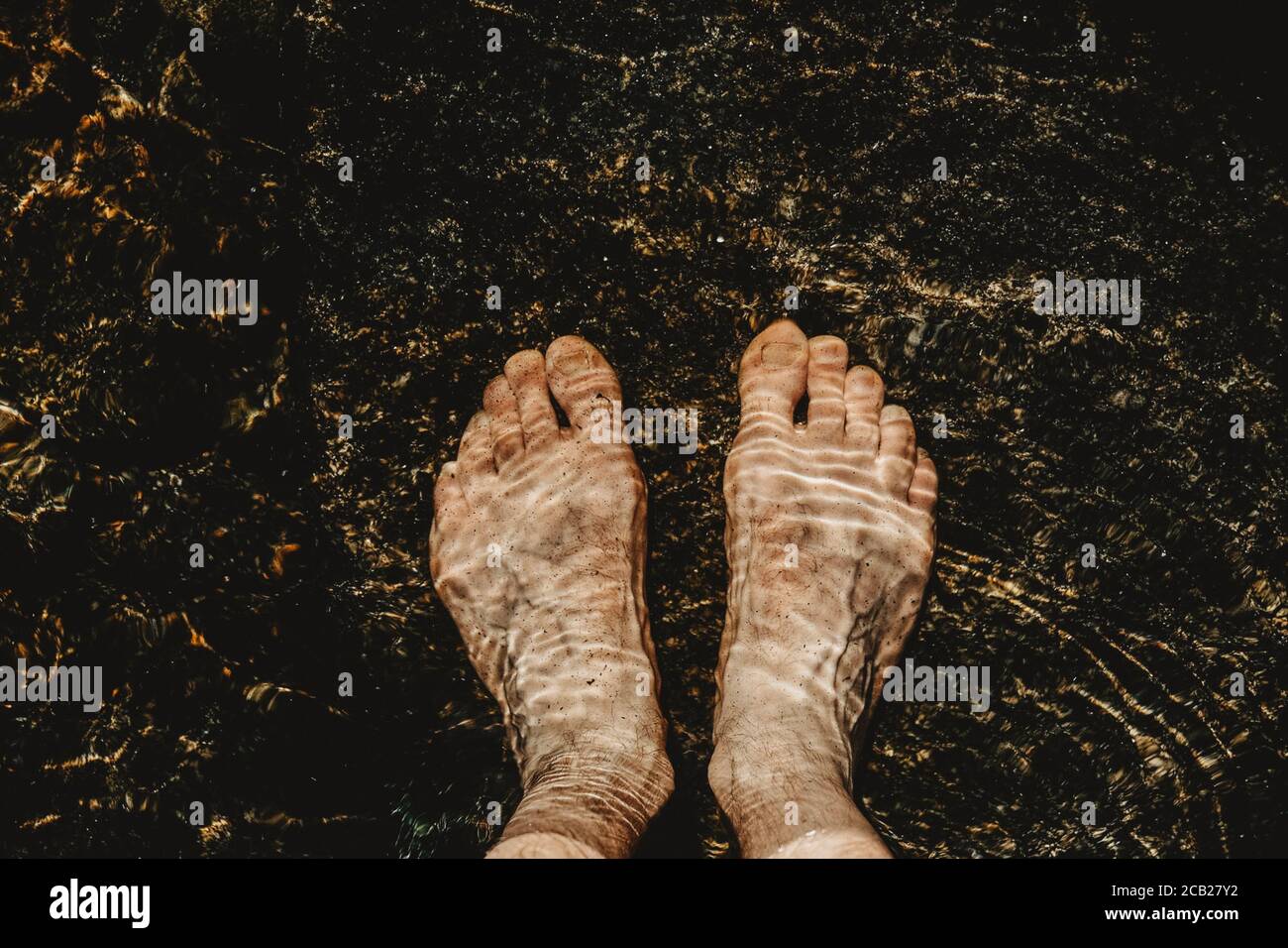 Top view of human feet in a crystal clear water Stock Photo - Alamy