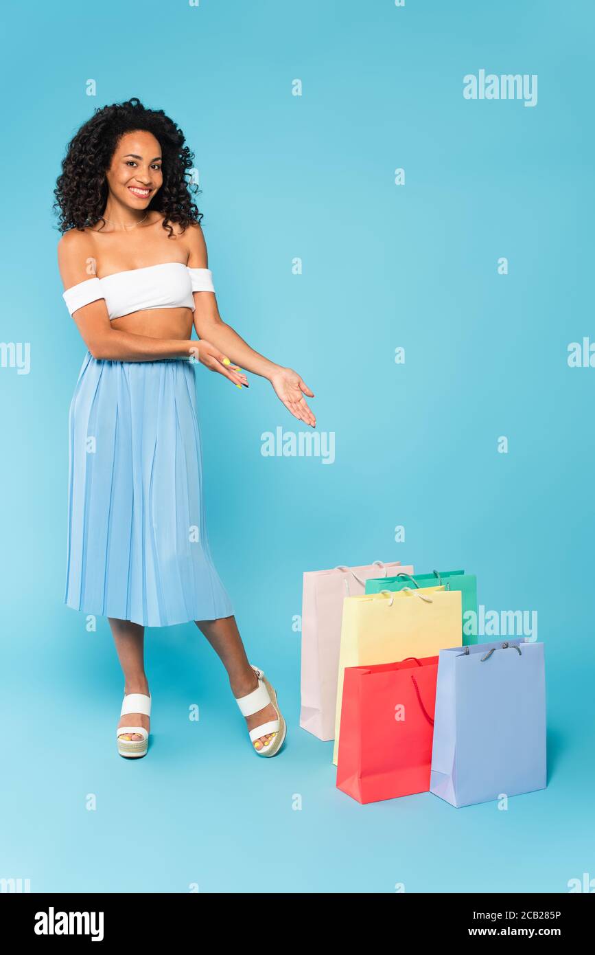 happy african american girl standing and pointing with hands at ...