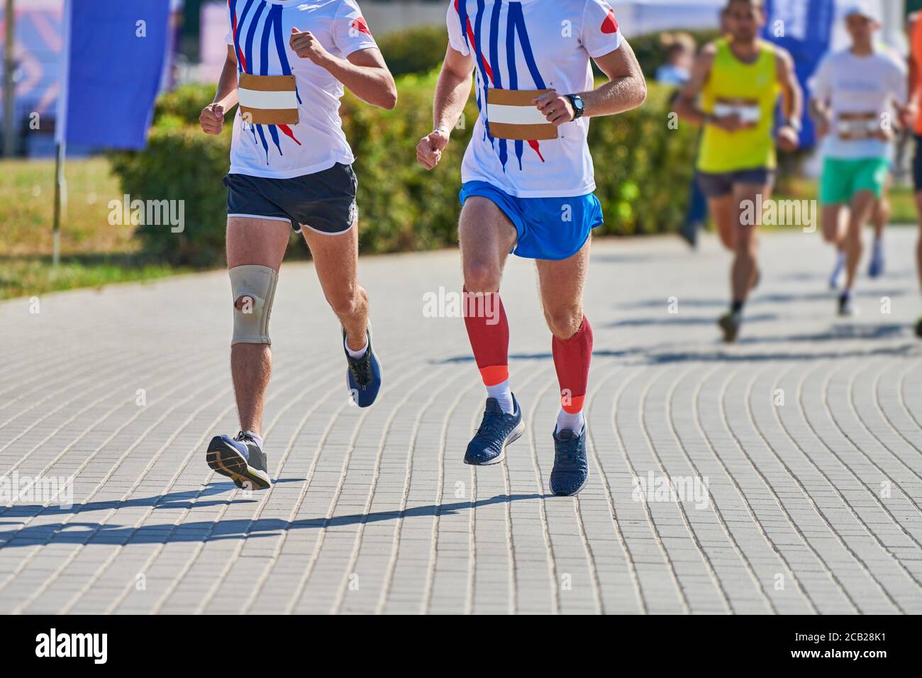 Marathon runners on city road. Running competition. Street sprinting ...