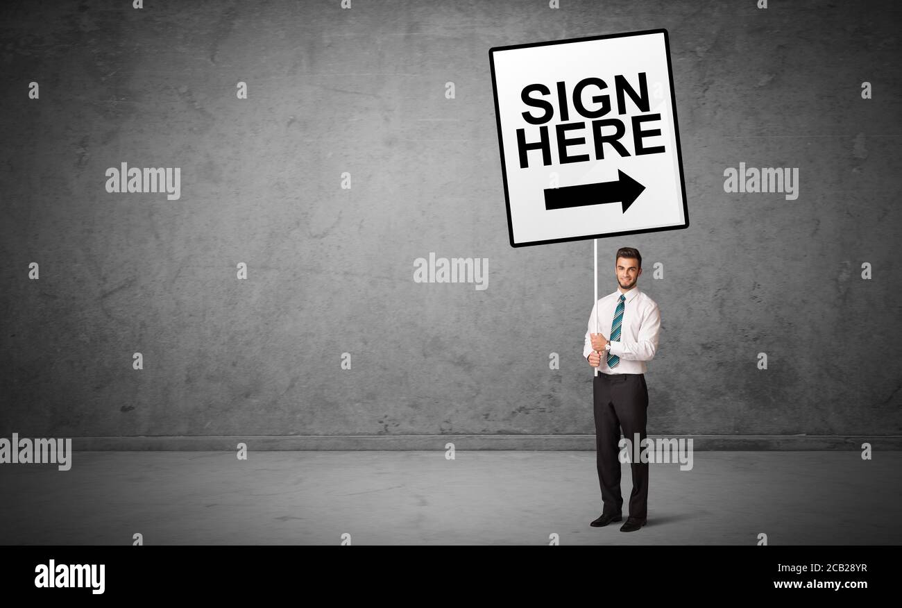 business person holding a traffic sign with SIGN HERE inscription, new ...