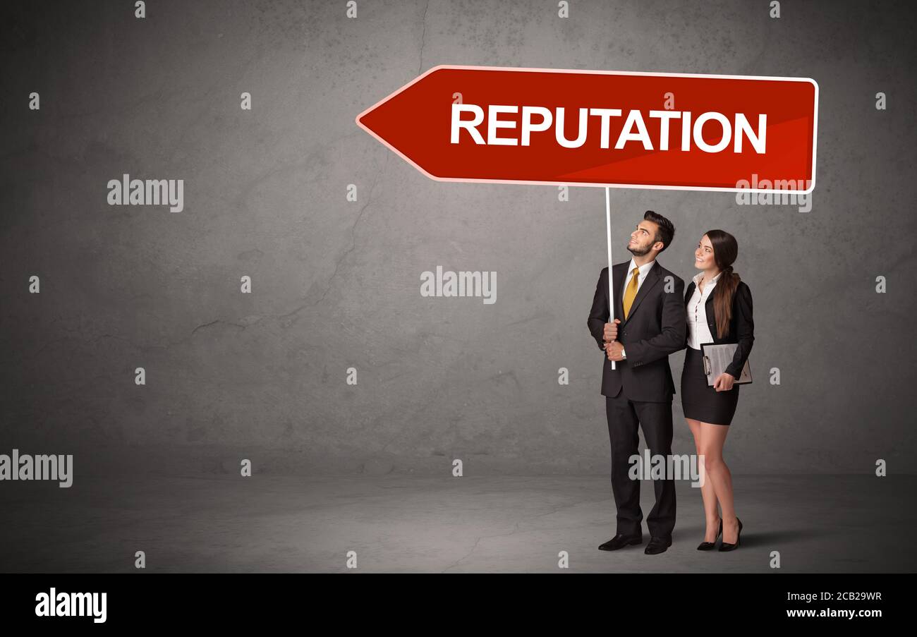 Young business person in casual holding road sign with REPUTATION ...