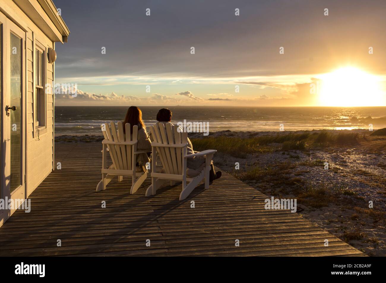 Romantic Couple Enjoying Sunset at Beach House Stock Photo - Alamy