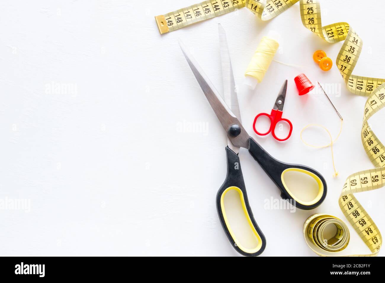 sewing accessories scissors, measuring tape, thread, needles on white ...