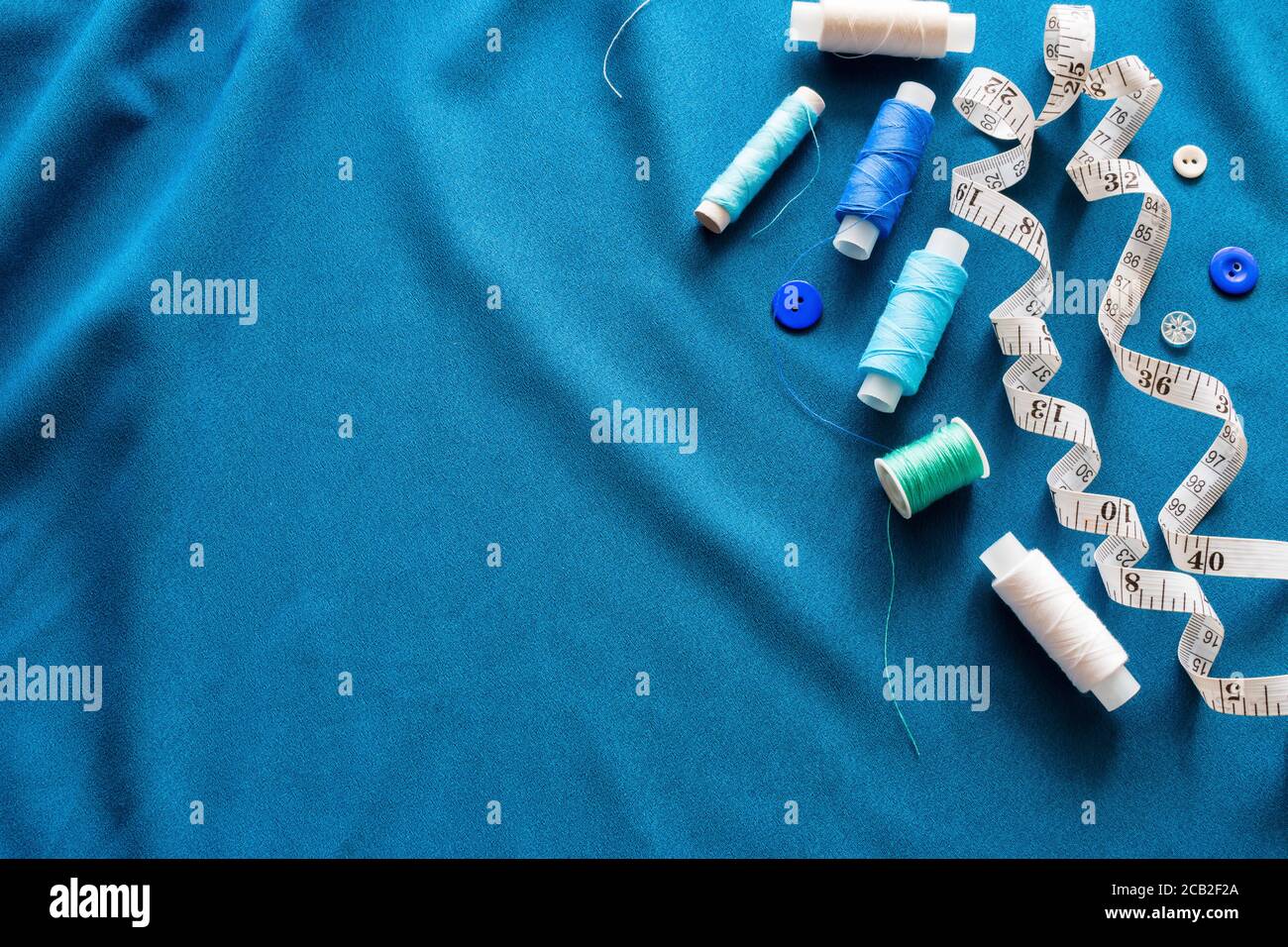 Thread and buttons on a blue background with space for text Stock Photo ...