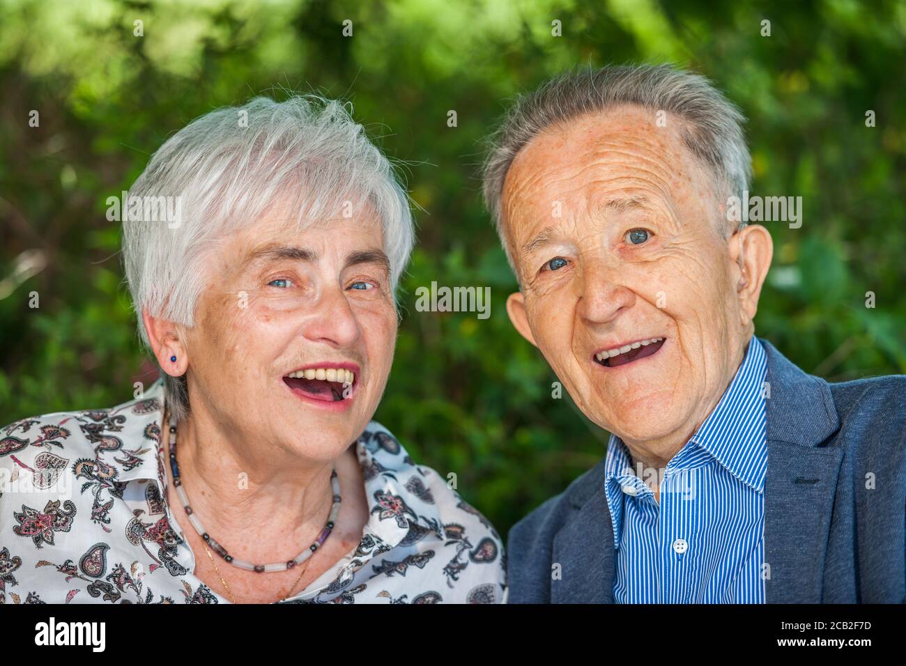Head-and-shoulder portrait of an 80 year old retired couple in front of ...