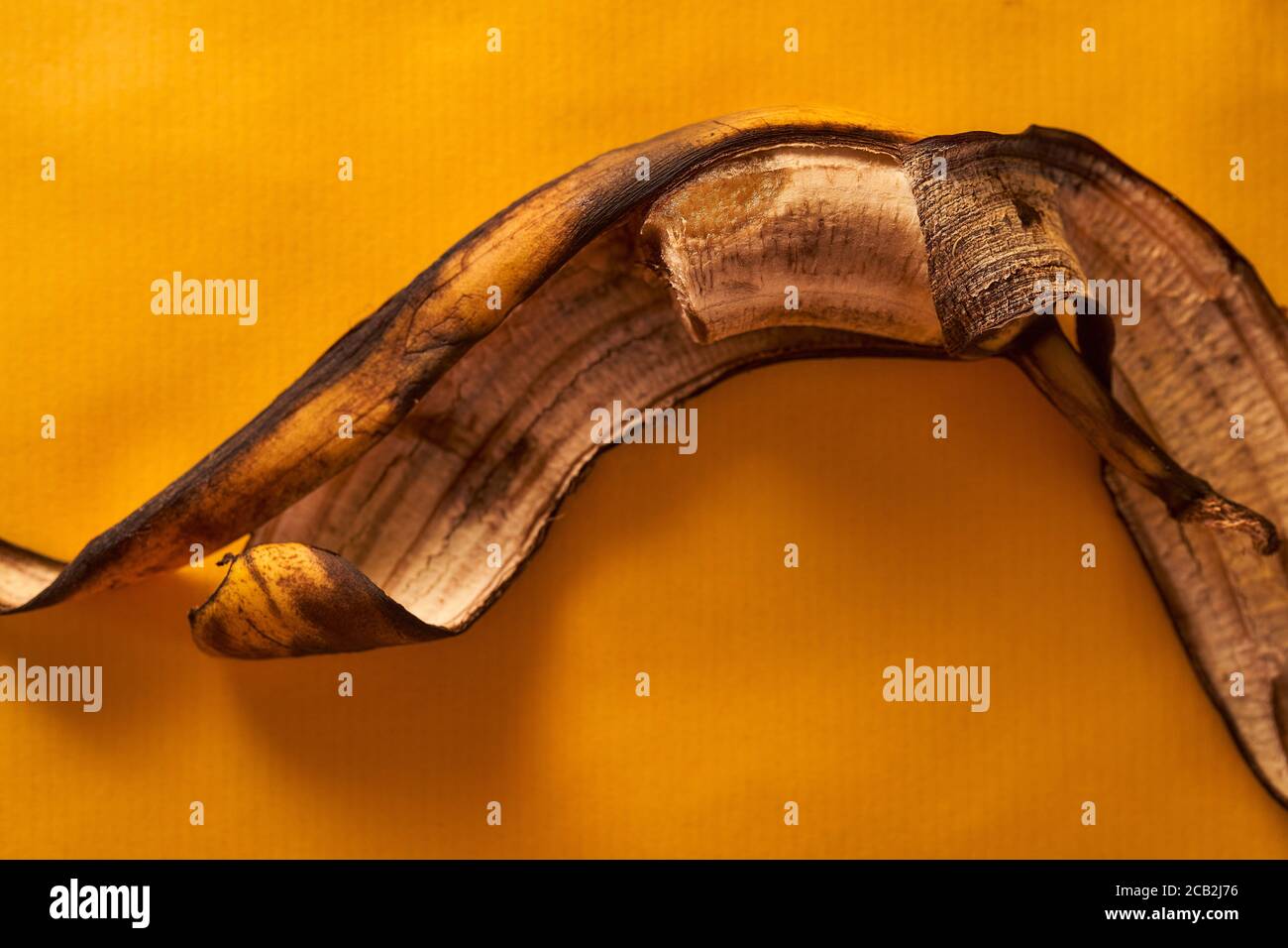 Spoiled ugly banana peel in the open on a yellow background Stock Photo ...