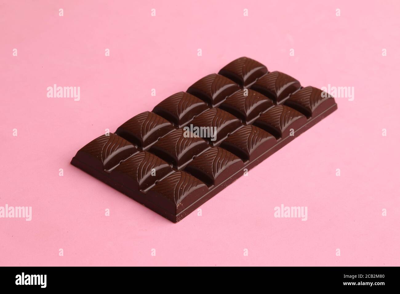 Sweet, brown chocolate bars on the pink surface Stock Photo - Alamy